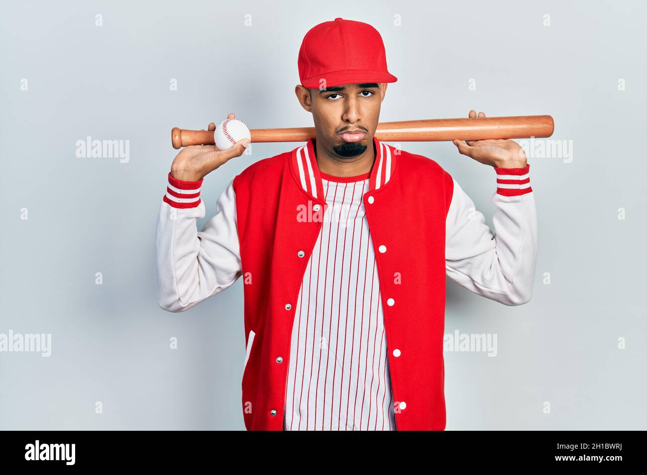 Young african american man playing baseball holding bat and ball ...
