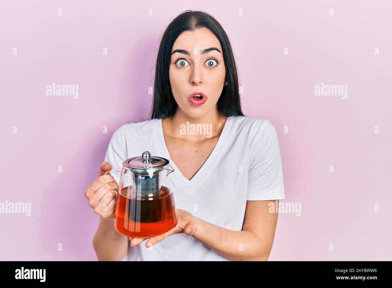 Beautiful woman with blue eyes wearing traditional tea pot scared and ...