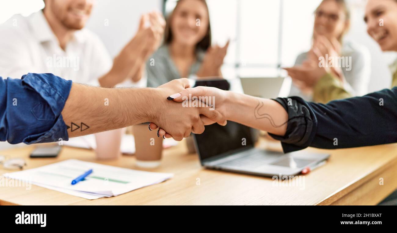 Group of business workers smiling and clapping to partners handshake at ...