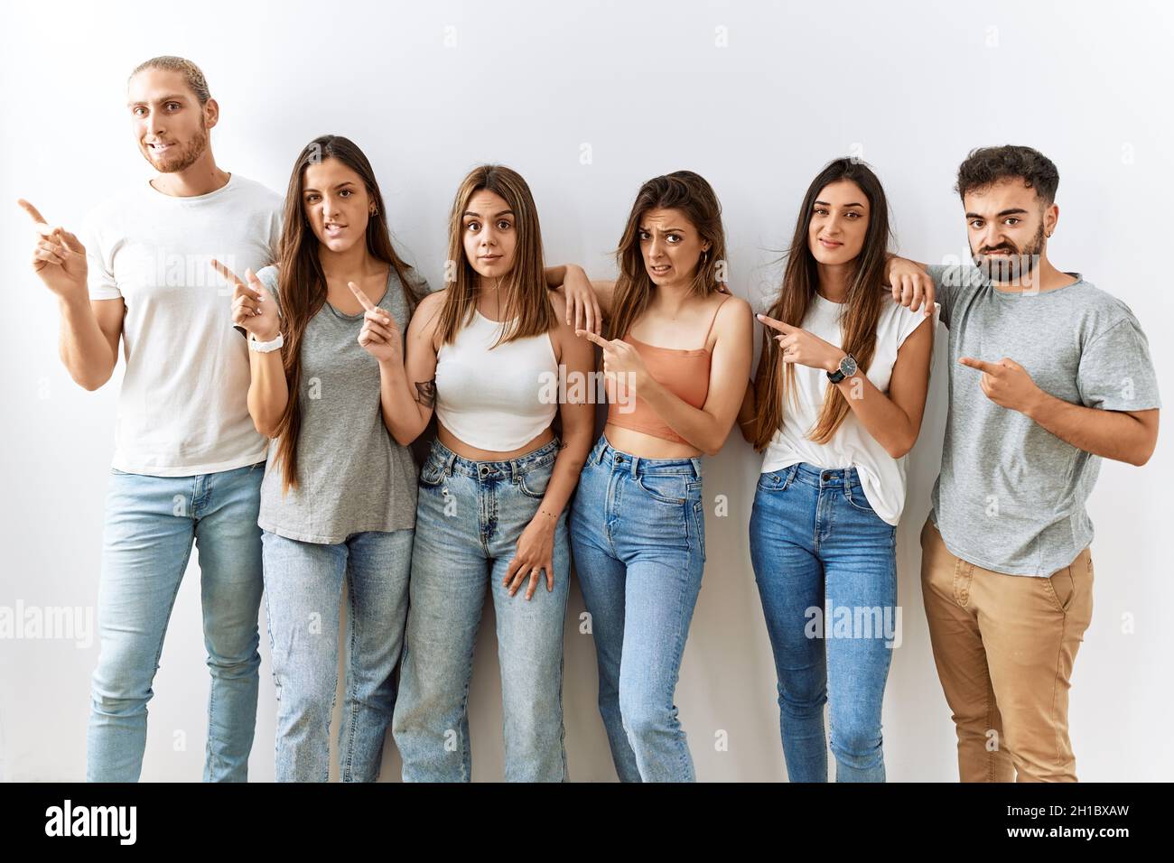Group of young friends standing together over isolated background ...