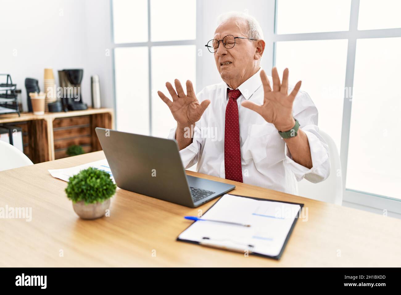 Senior man working at the office using computer laptop moving away ...