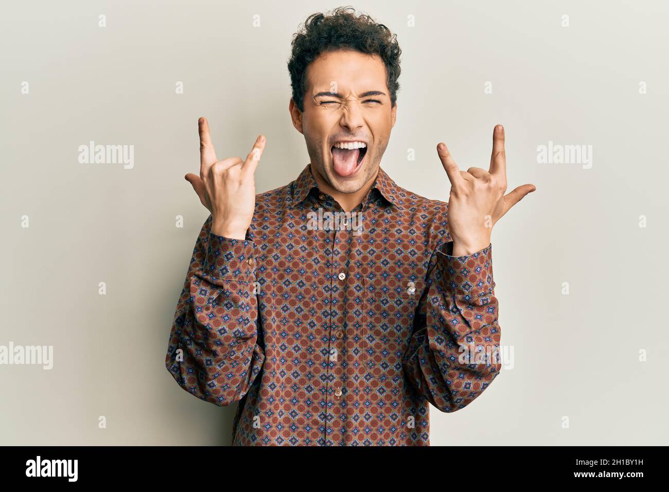 Handsome hispanic man wearing casual clothes shouting with crazy ...