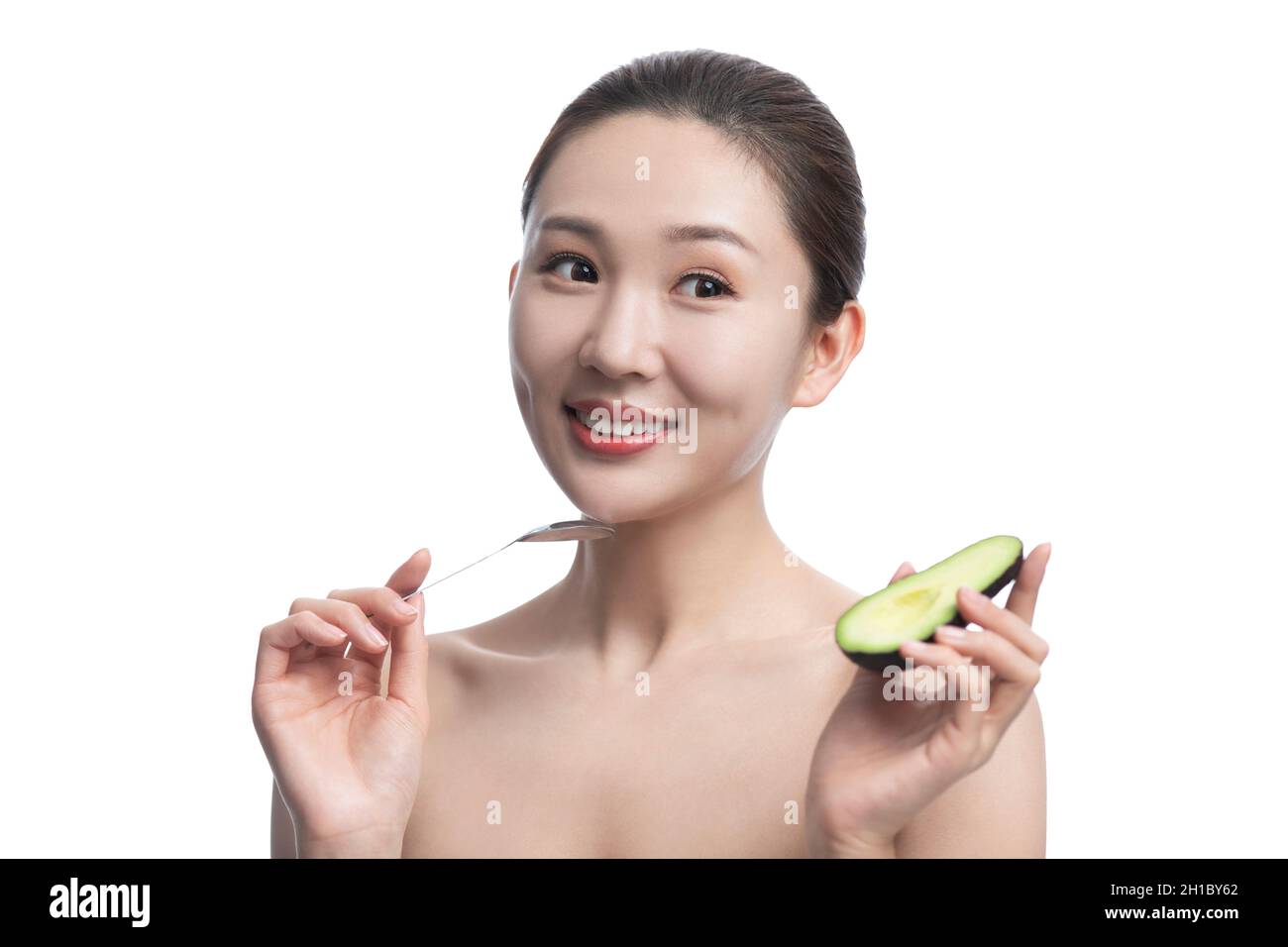 Beautiful young woman eating avocado Stock Photo - Alamy