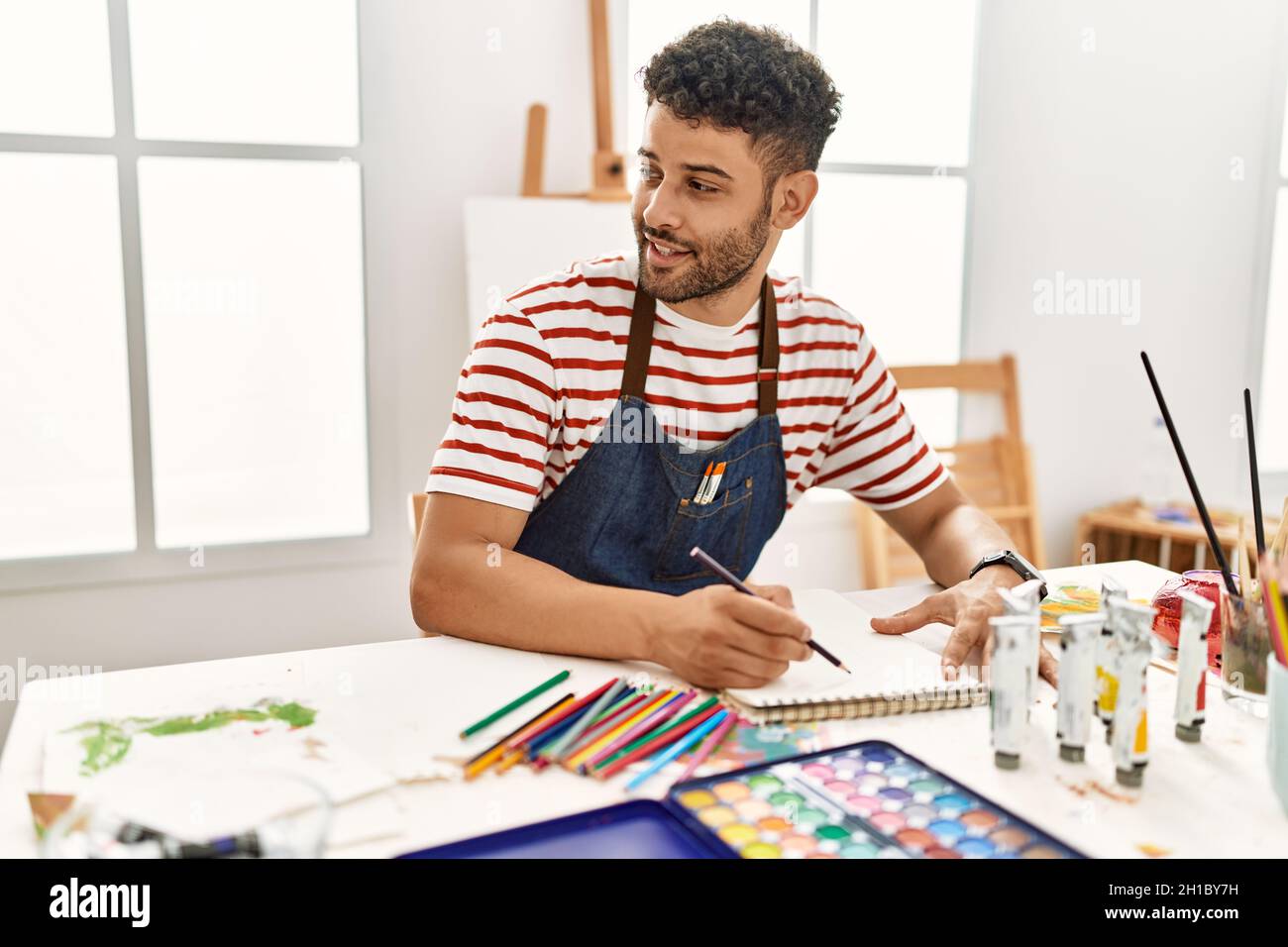 Young arab artist man smiling happy drawing at art studio Stock Photo ...