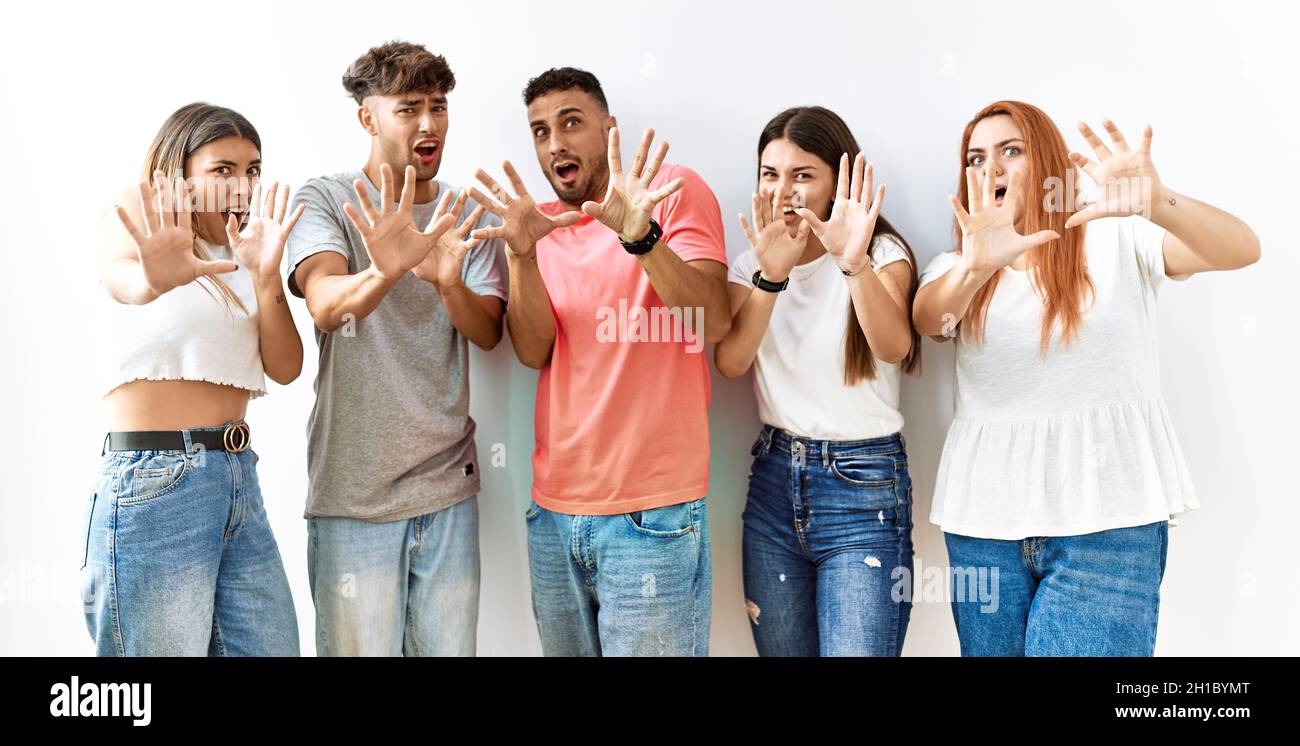 Group of young friends standing together over isolated background ...