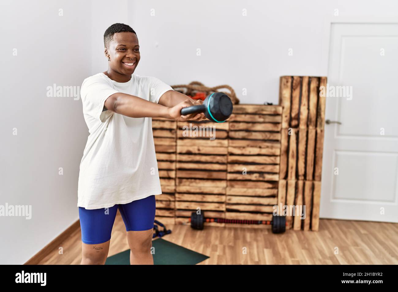 Young african man training with dumbbells at the gym Stock Photo - Alamy