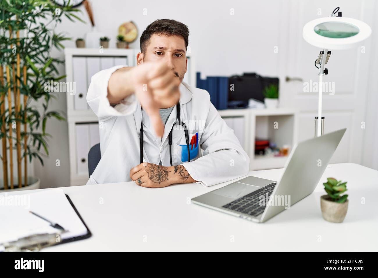 Young doctor working at the clinic using computer laptop looking ...