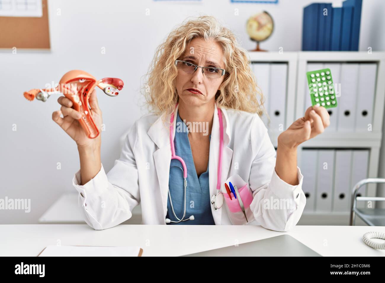 Middle age doctor woman holding birth control pills depressed and worry ...
