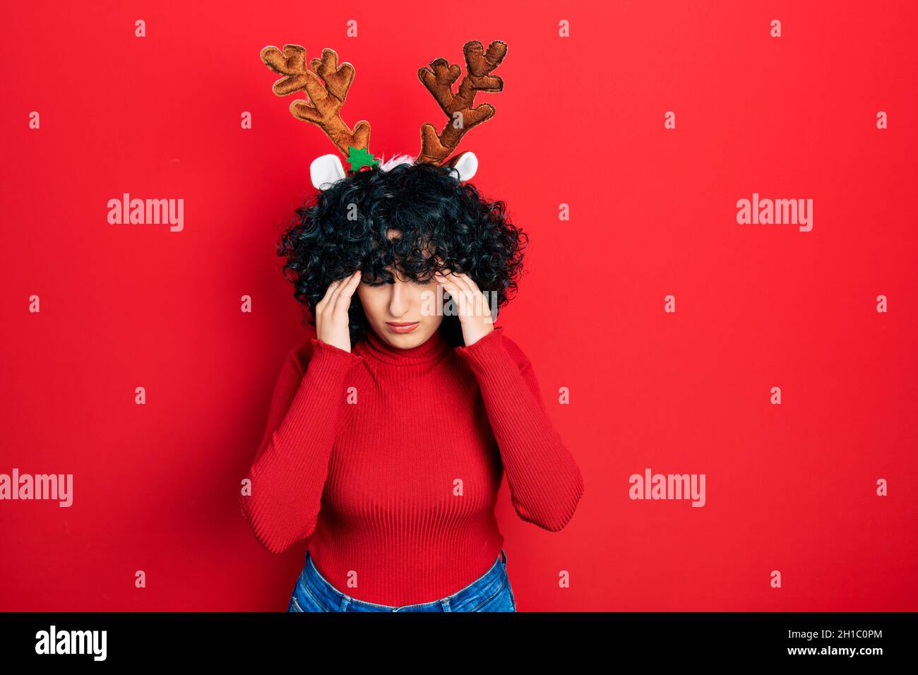 Young middle east woman wearing cute christmas reindeer horns with hand ...