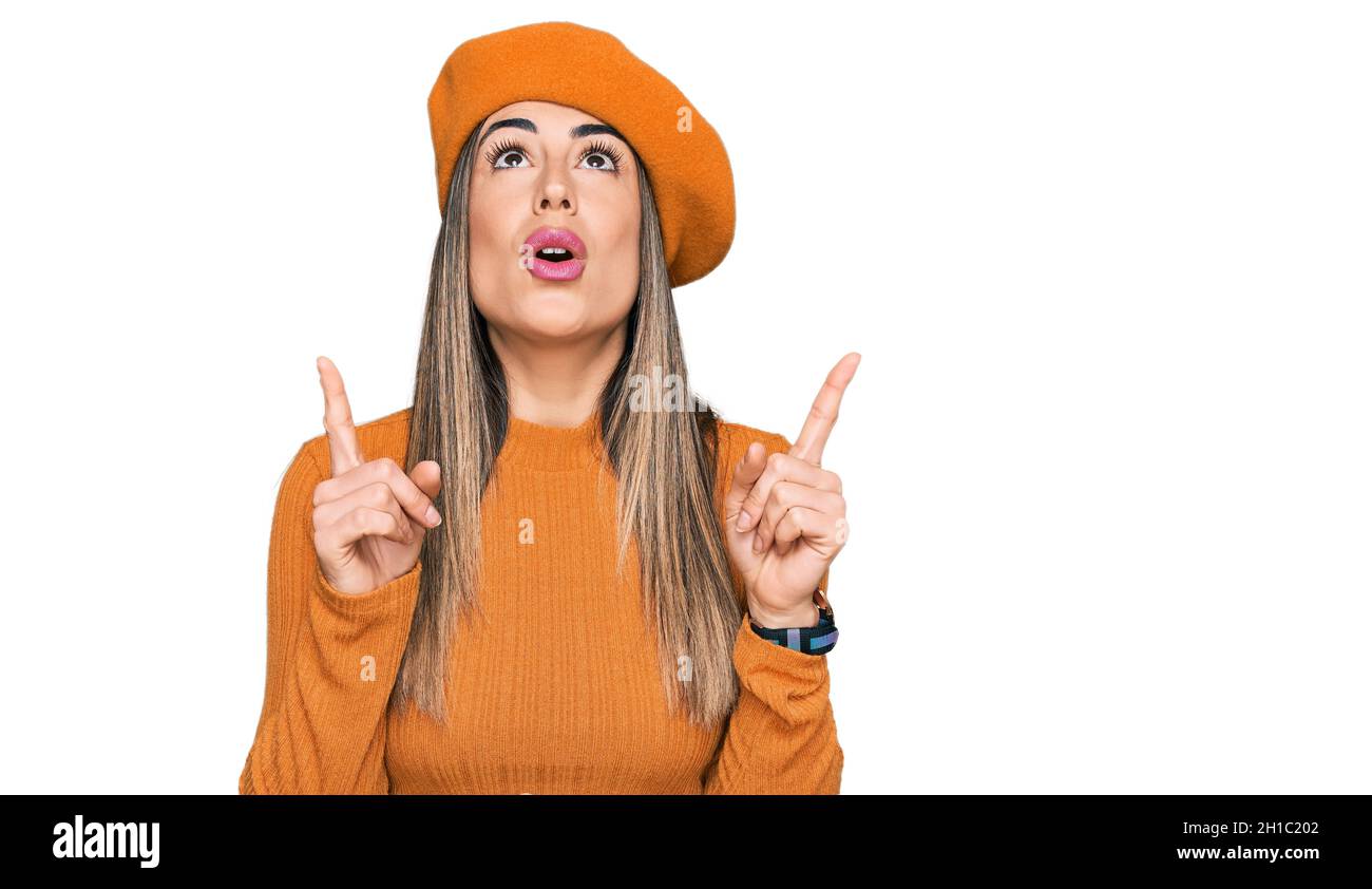 Young hispanic woman wearing french look with beret amazed and ...