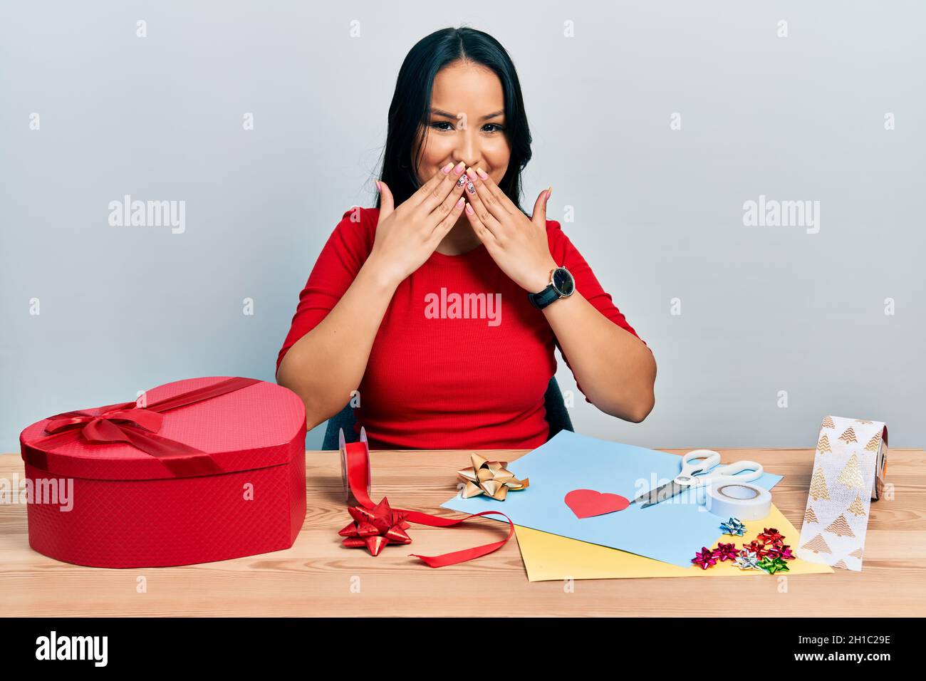 Beautiful hispanic woman with nose piercing doing handcraft creative ...