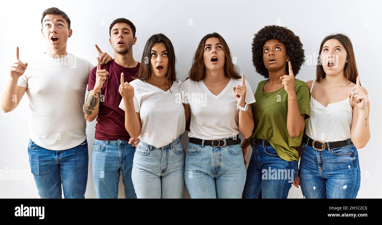 Group of young friends standing together over isolated background ...