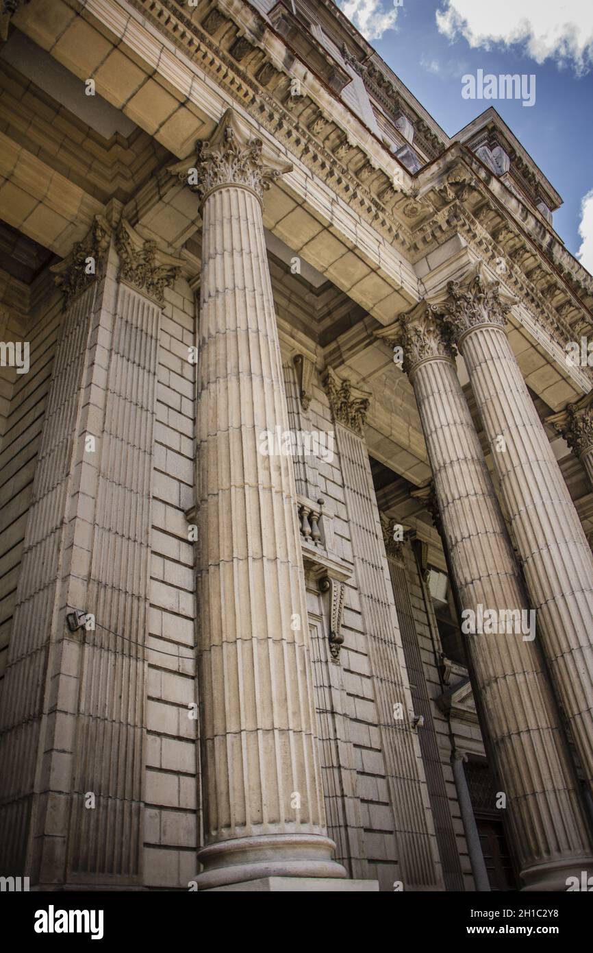 Historical old building external view with columns against a cloudy sky ...