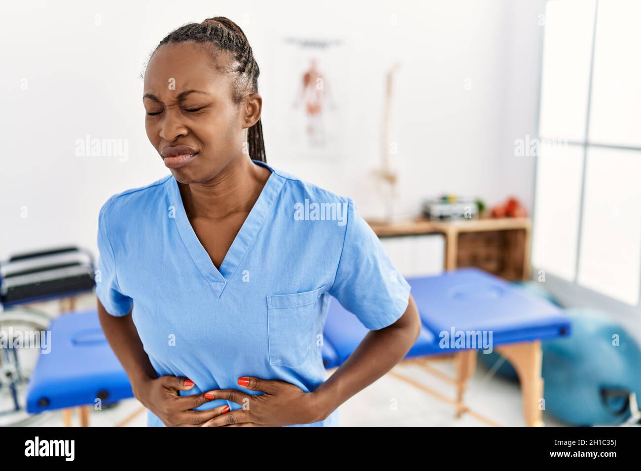 Black woman with braids working at pain recovery clinic with hand on ...