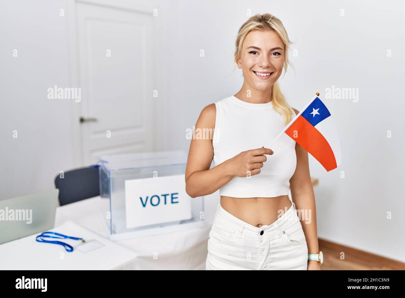 Young caucasian woman at political campaign election holding chile flag ...