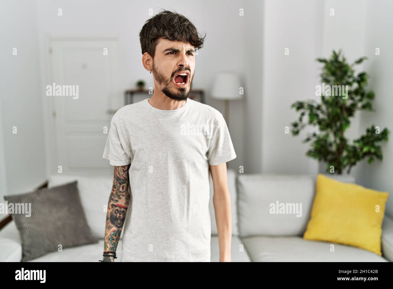 Hispanic man with beard at the living room at home angry and mad ...
