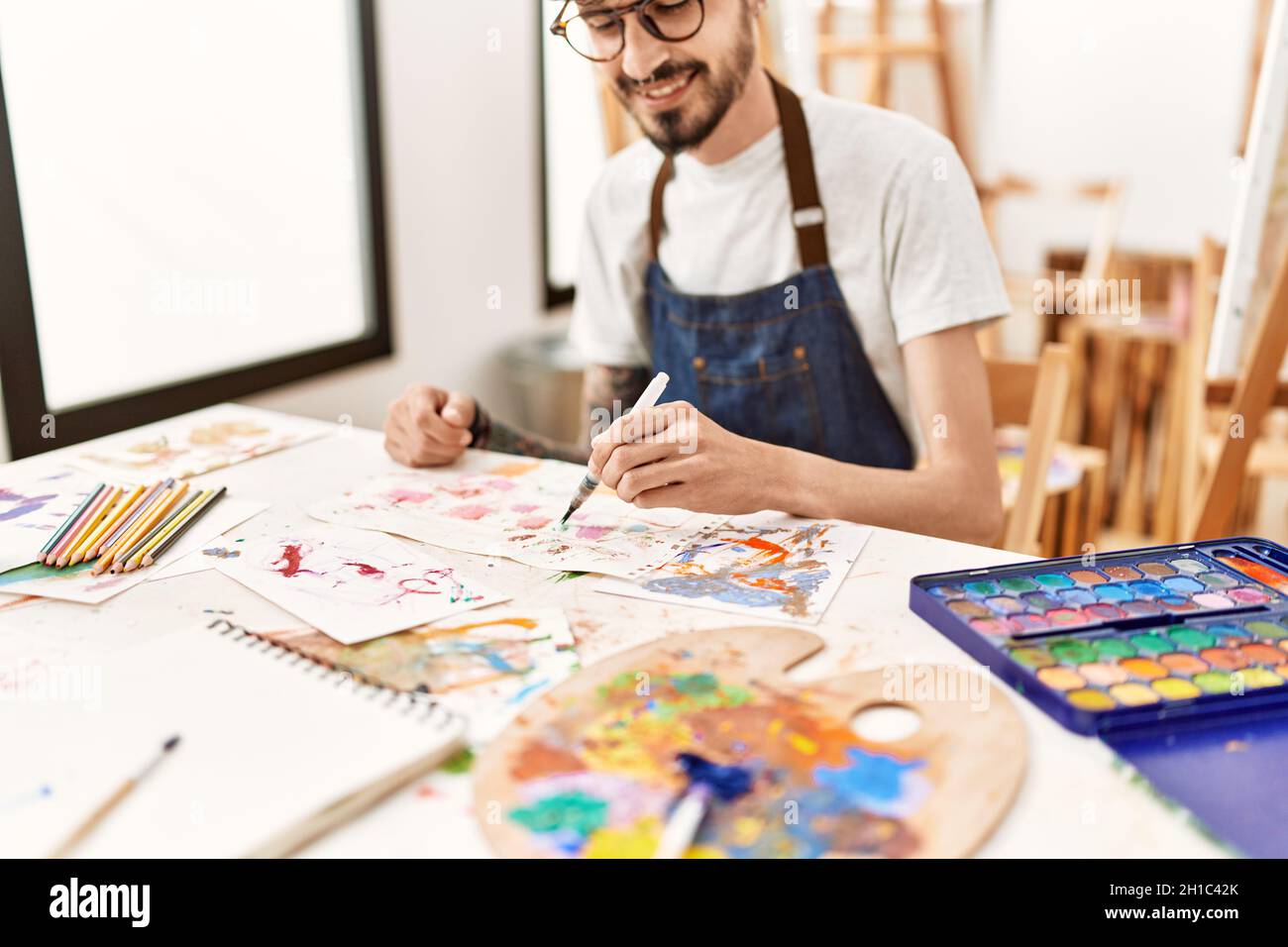 Young hispanic artist man smiling happy drawing at art studio Stock ...