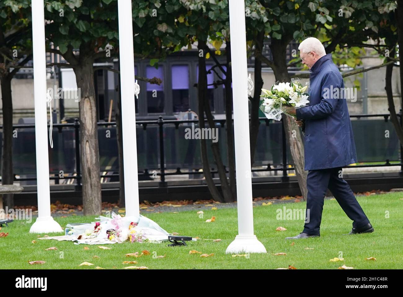 Labour MP John Cryer lays flowers inside the gates at the Houses of ...