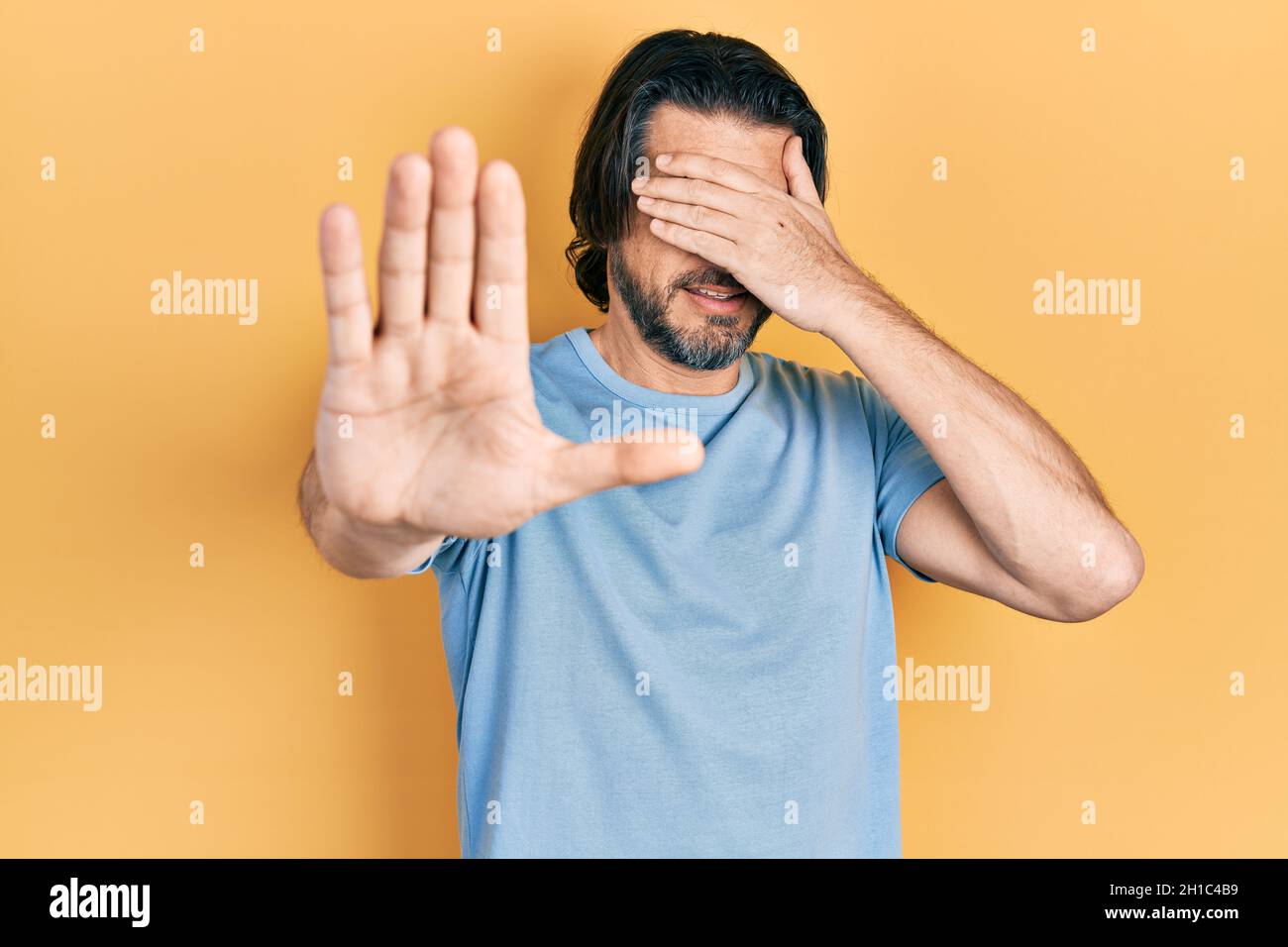 Middle age caucasian man wearing casual clothes covering eyes with ...