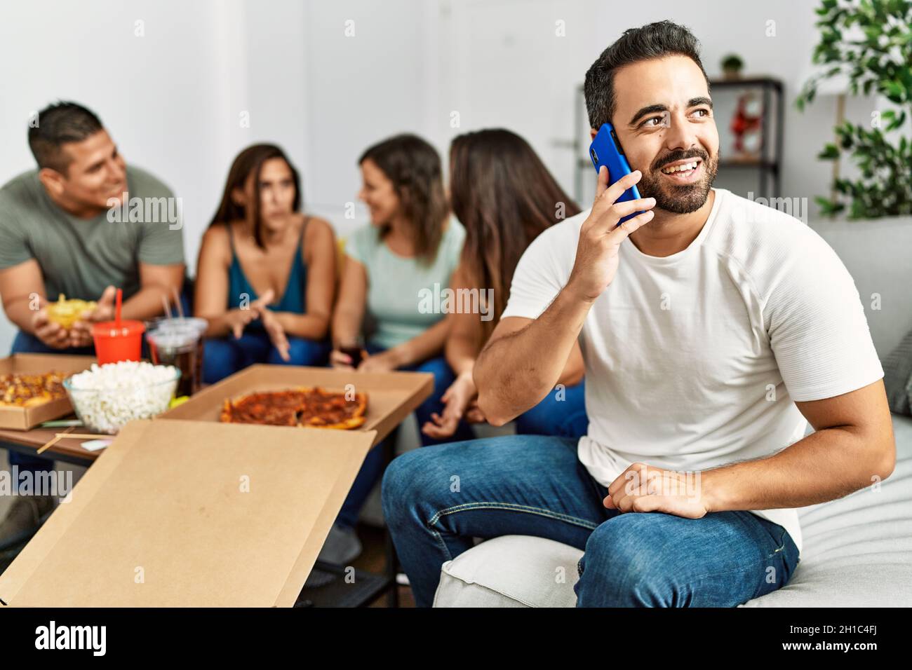 Group of young hispanic friends eating italian pizza sitting on the ...