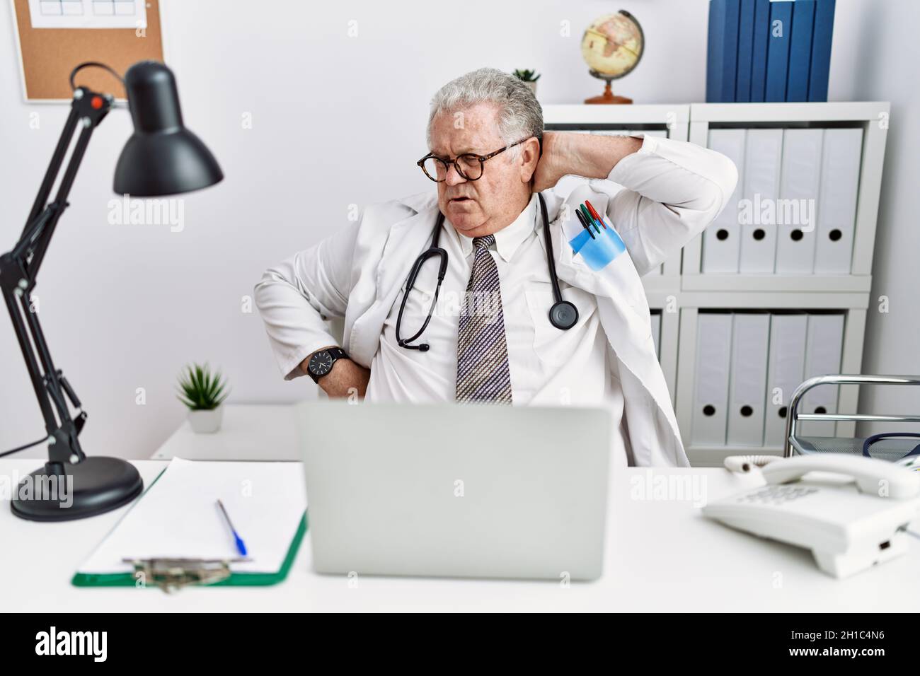 Senior caucasian man wearing doctor uniform and stethoscope at the ...