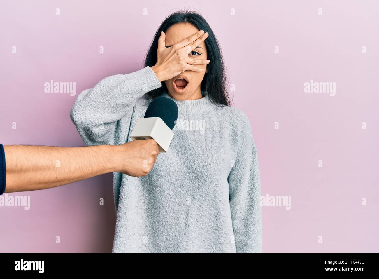 Young hispanic girl being interviewed by reporter holding microphone ...