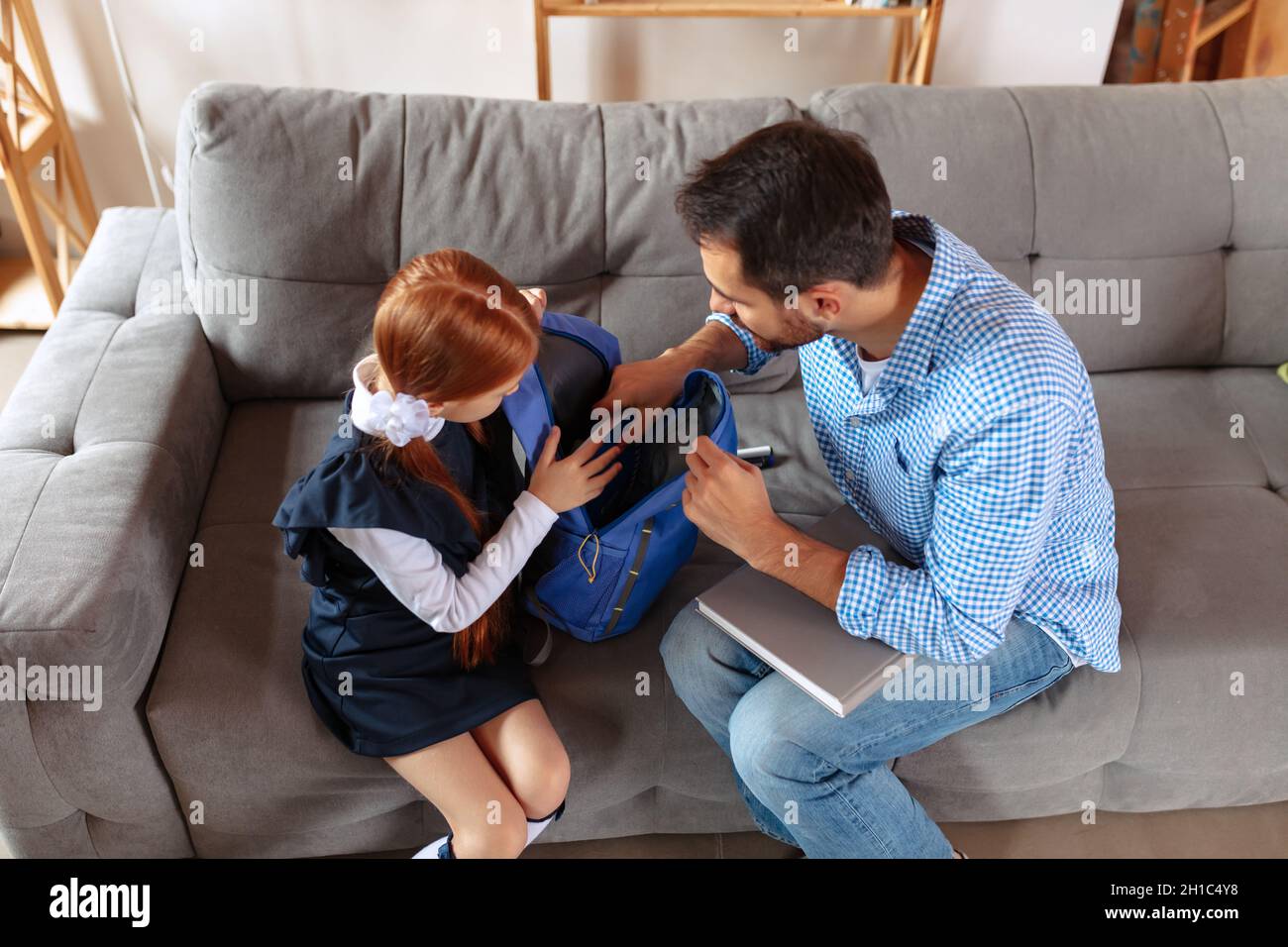 Top view image of father and daughter, pupil packing school backpack ...