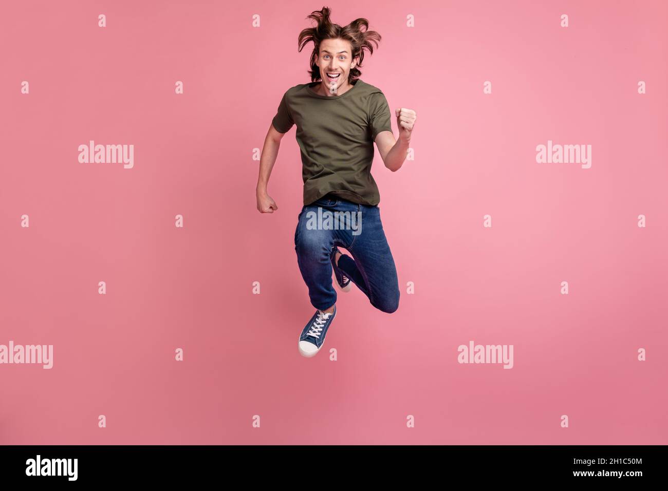 Full body photo of young guy happy positive smile go runner fast jump ...