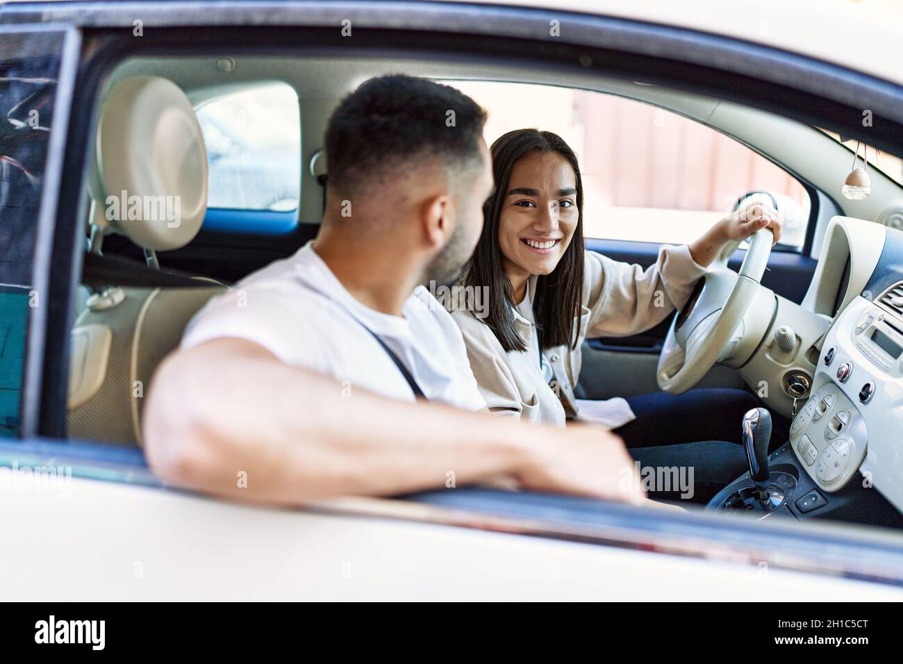 Young hispanic couple smiling happy driving car at the city Stock Photo ...
