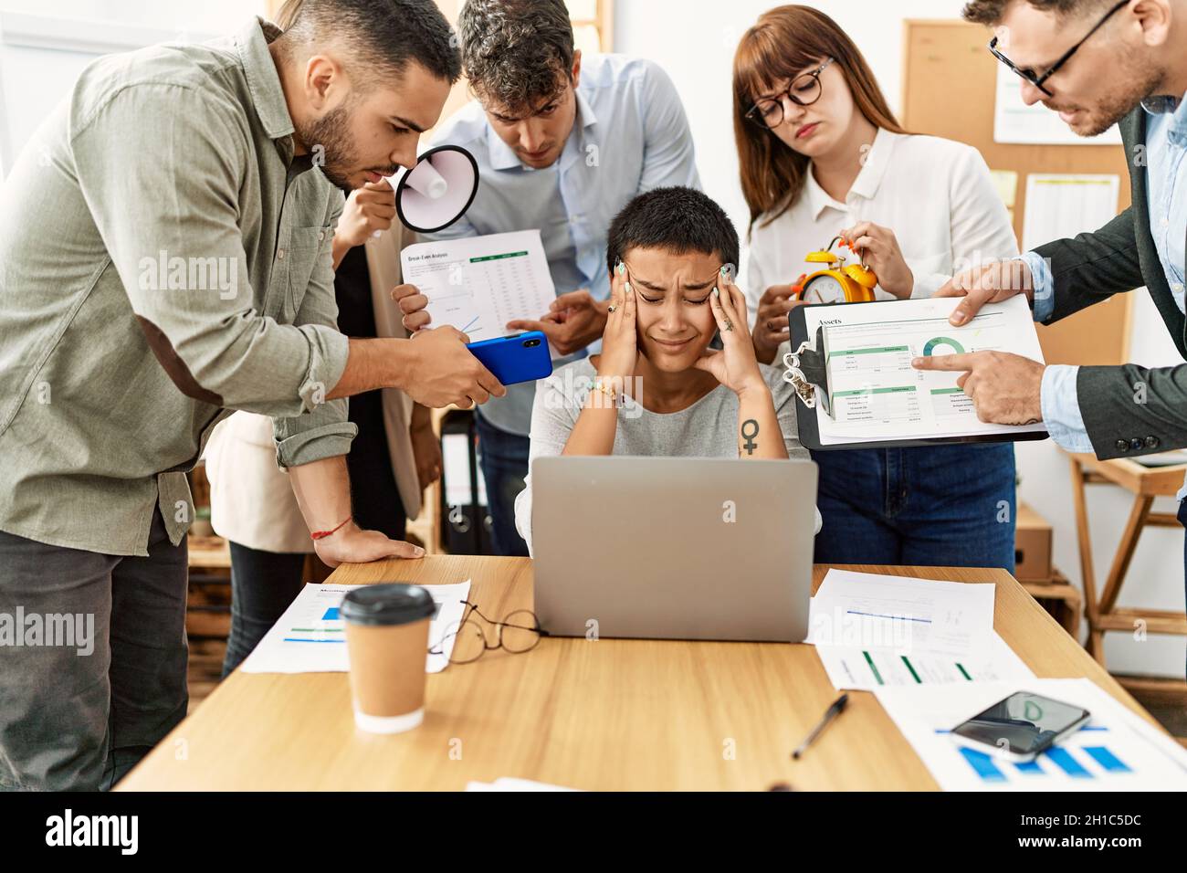 Group of business workers screaming to stressed partner at the office ...