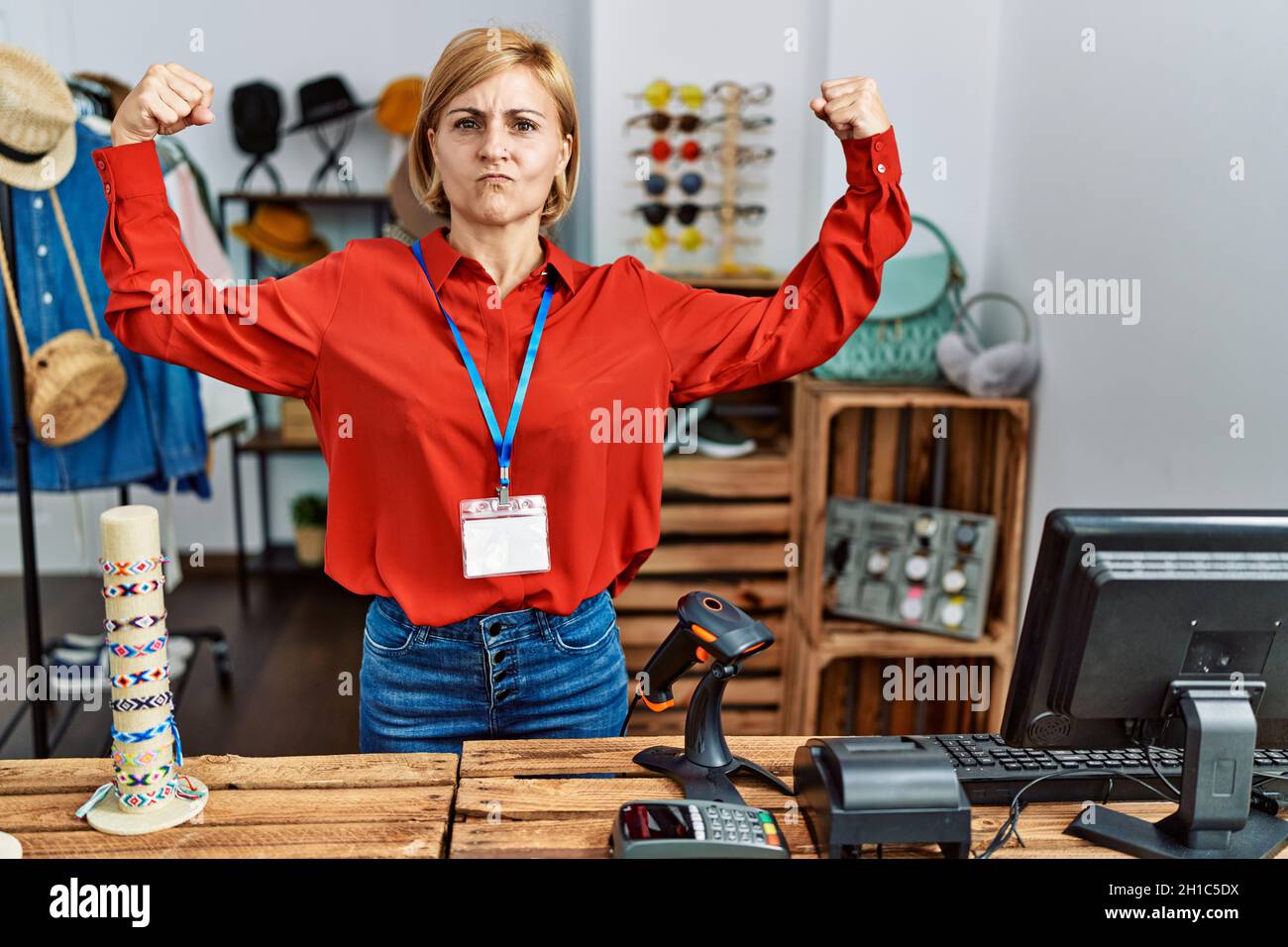 Middle age blonde woman working working as manager at retail boutique ...