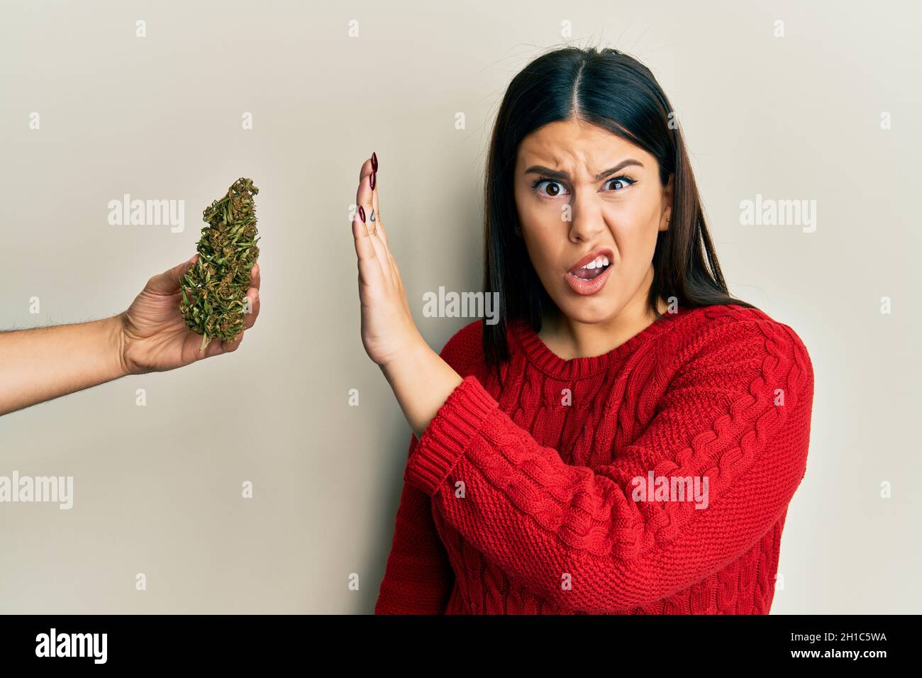Beautiful brunette woman saying no to marijuana herb clueless and ...