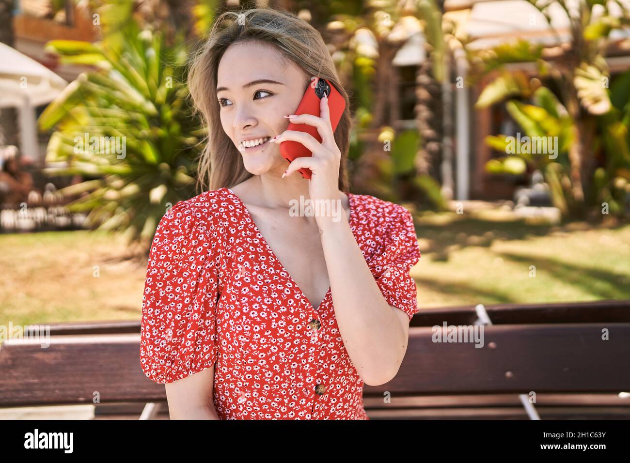 Young chinese girl smiling happy talking on the smartphone sitting on ...