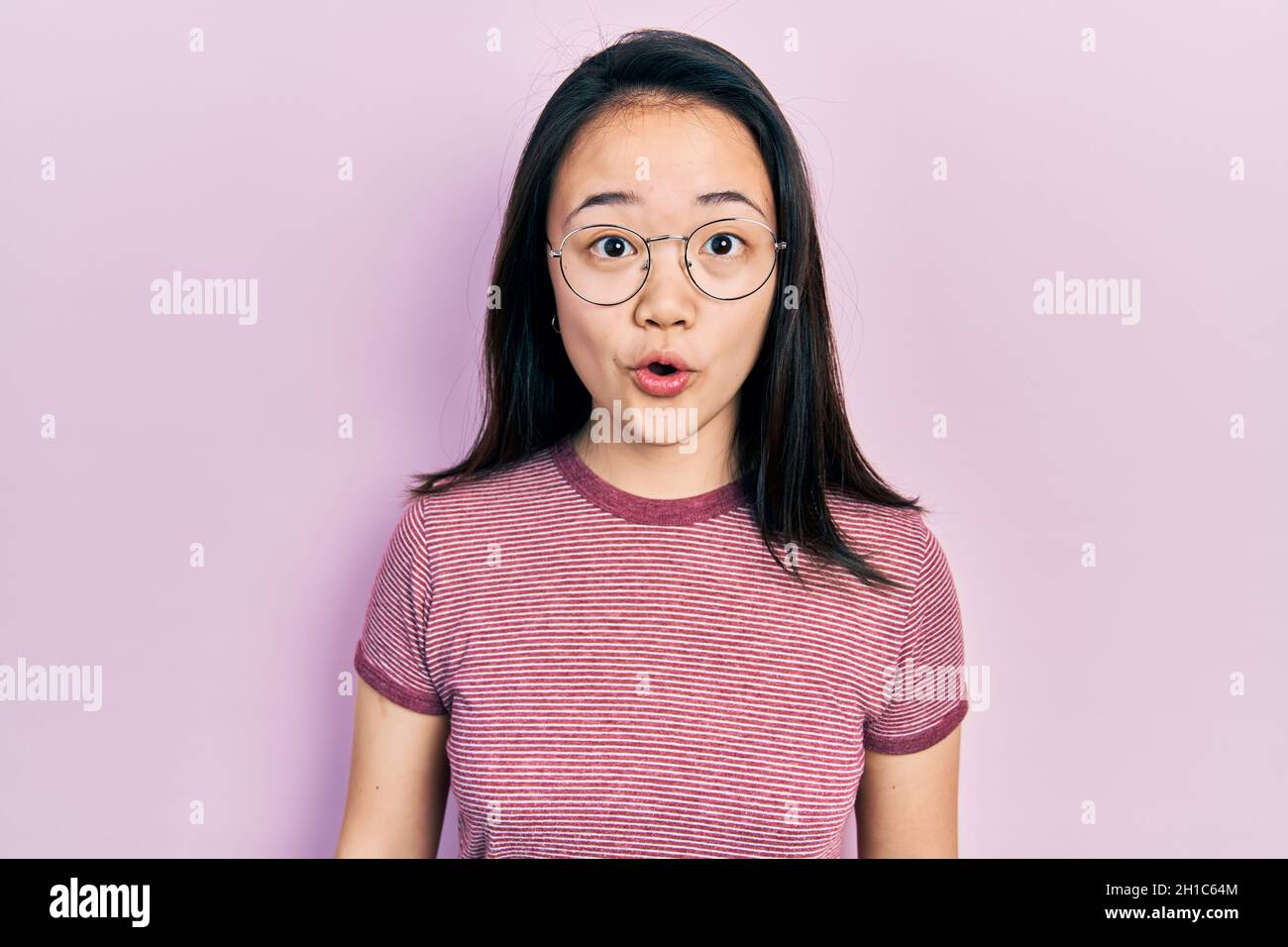 Young chinese girl wearing casual clothes and glasses afraid and ...