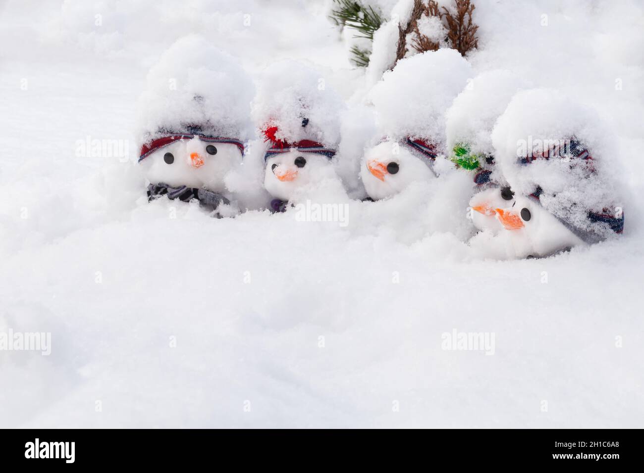 Five little cute snowmen covered in a fresh snowfall wearing hats and ...