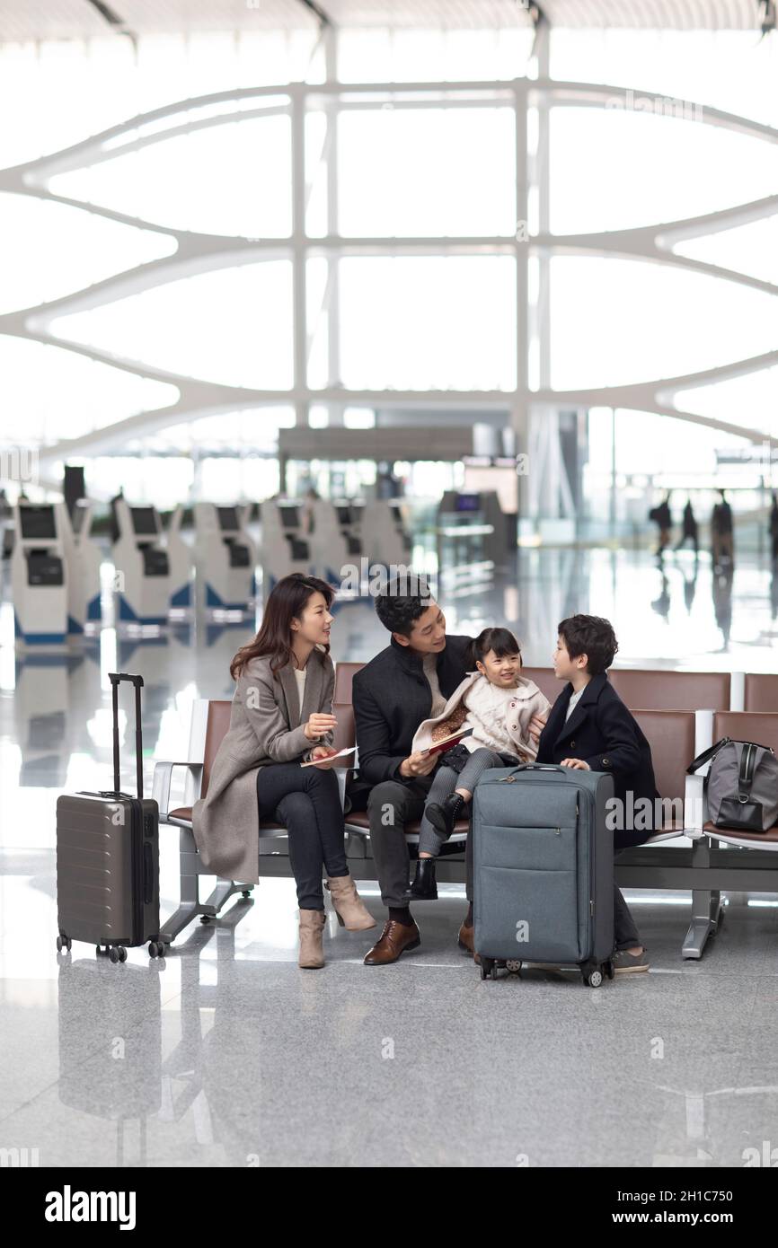 Happy young family waiting for flight at the airport Stock Photo - Alamy