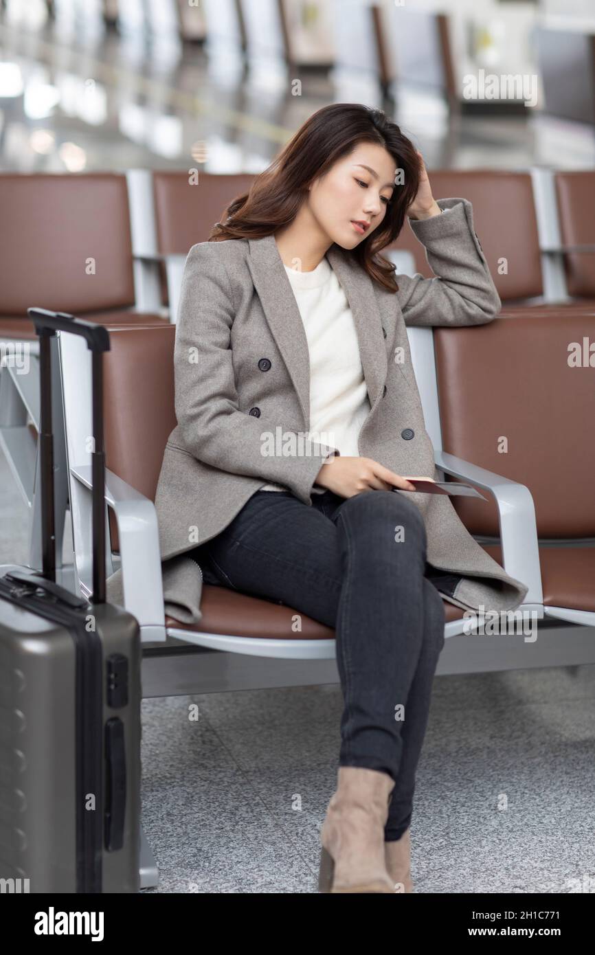 Young woman waiting for flight at the airport Stock Photo - Alamy