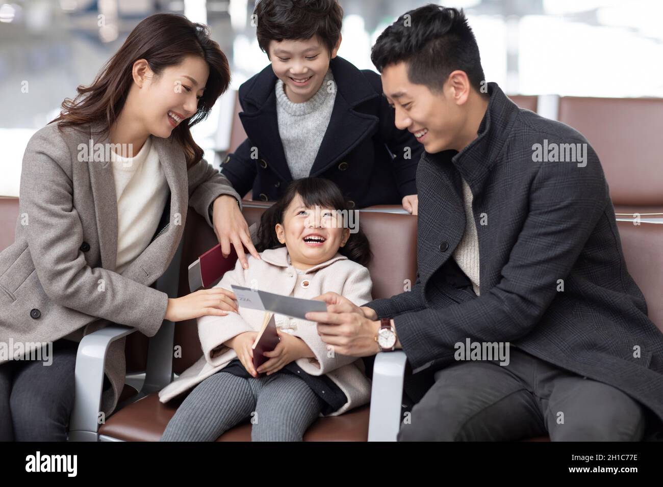 Happy young family waiting for flight at the airport Stock Photo - Alamy
