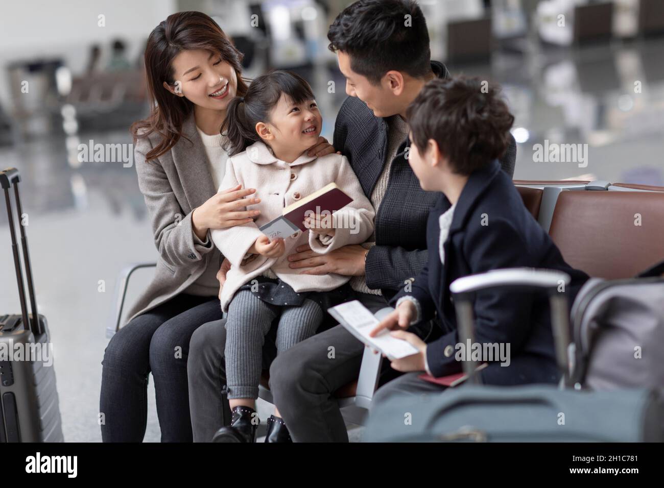 Happy young family waiting for flight at the airport Stock Photo - Alamy