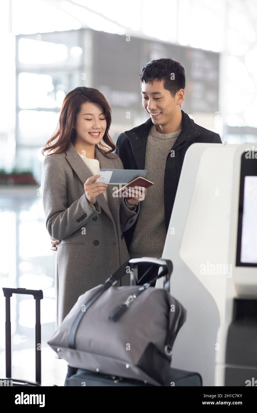Happy young couple doing self check-in at the airport Stock Photo - Alamy