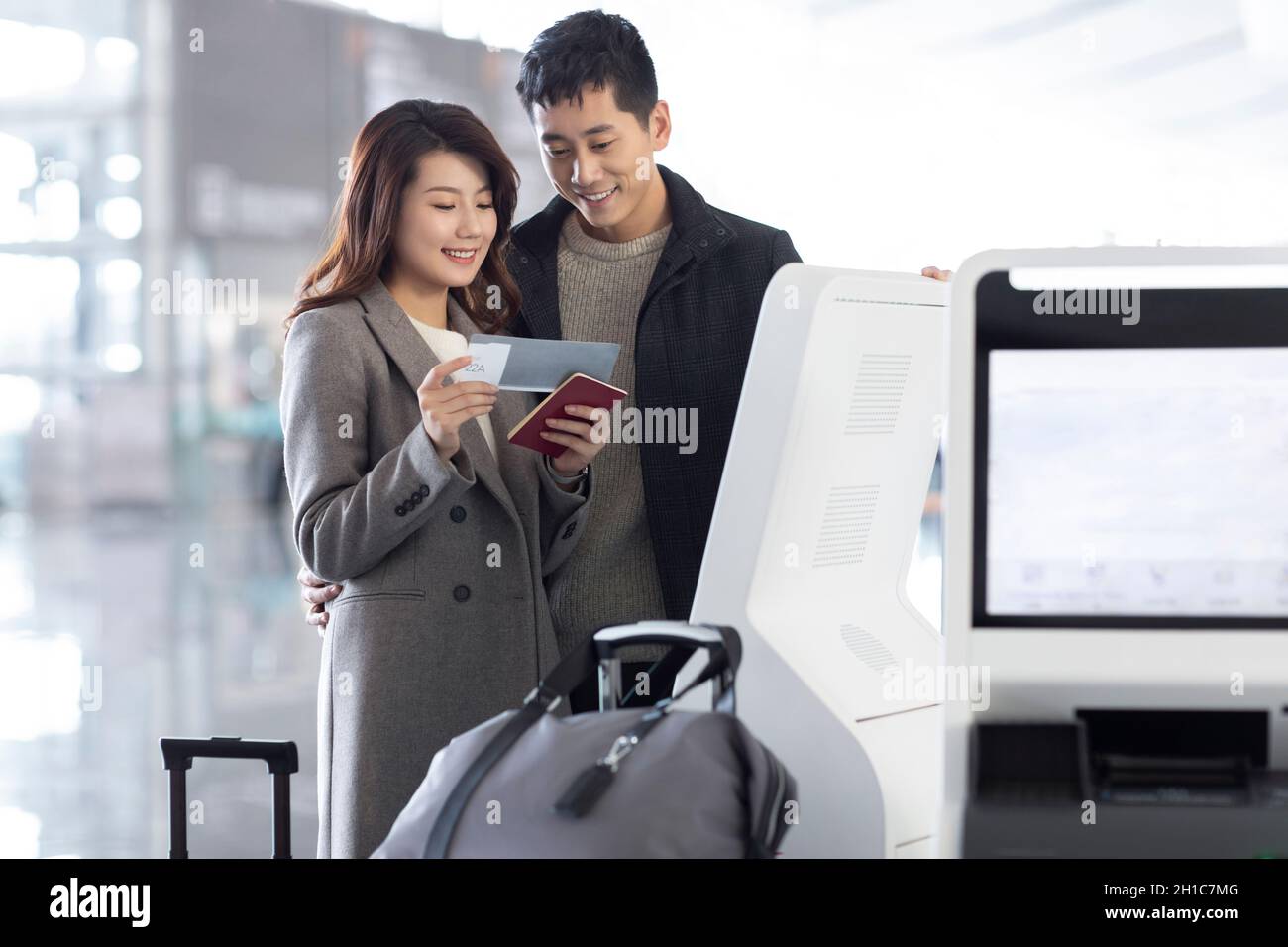 Happy young couple doing self check-in at the airport Stock Photo - Alamy