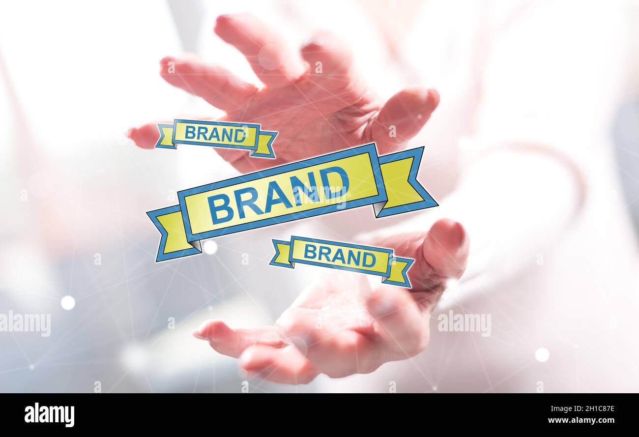 Brand concept between hands of a woman in background Stock Photo - Alamy