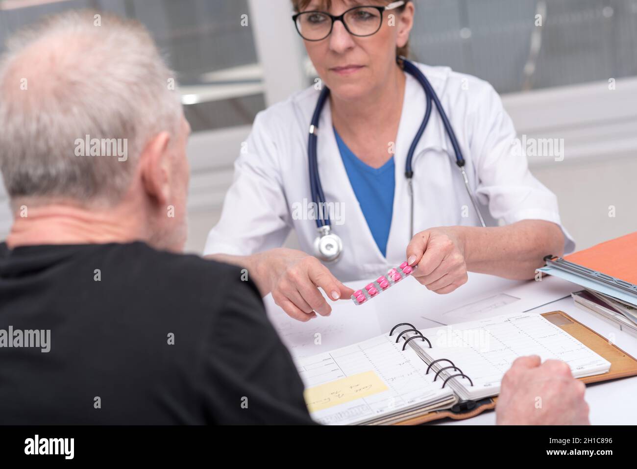 Female doctor explaining medicine to her patient in medical office ...