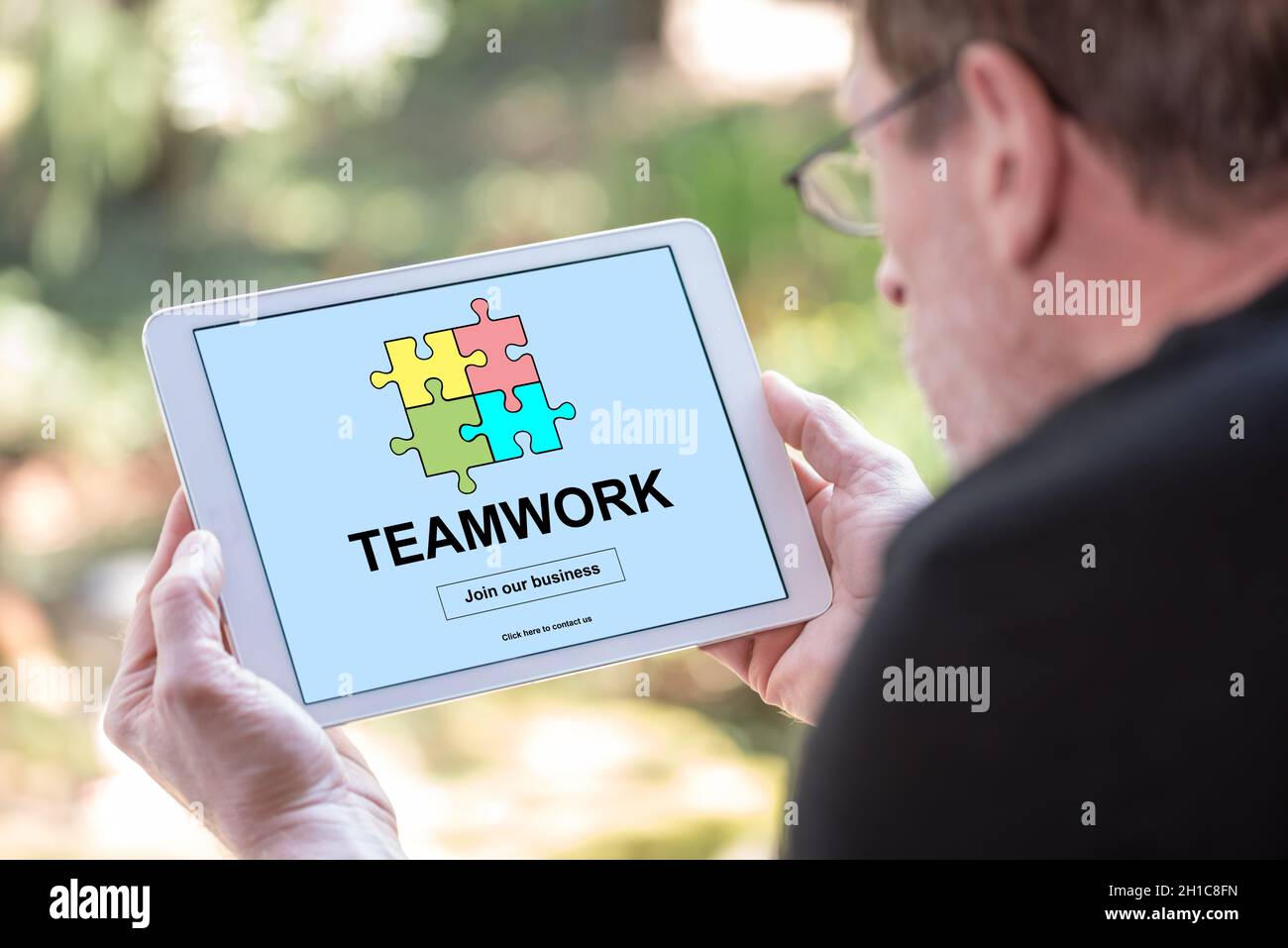 Tablet screen displaying a teamwork concept Stock Photo - Alamy