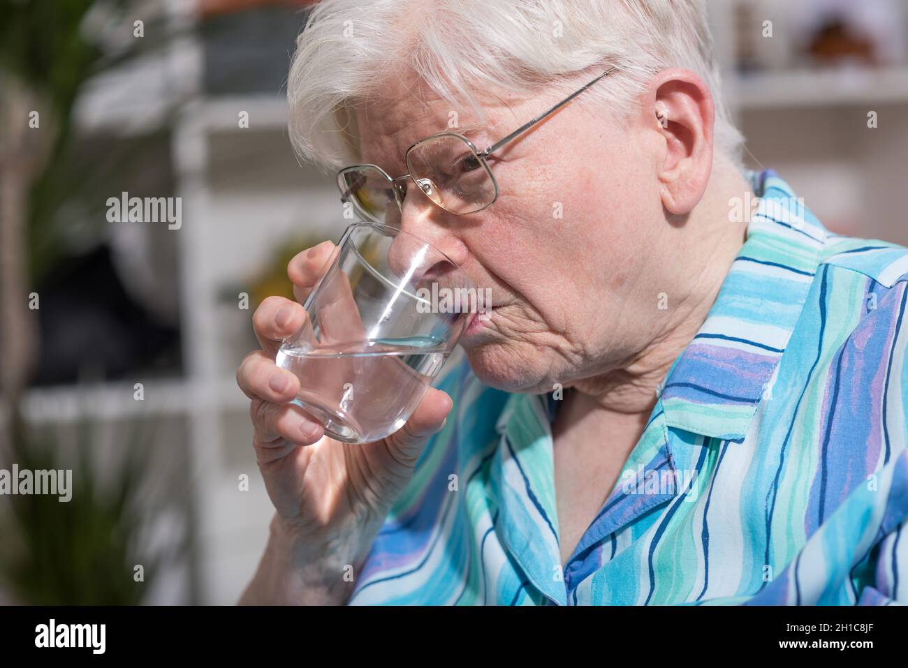 Senior drinking water at home Stock Photo - Alamy