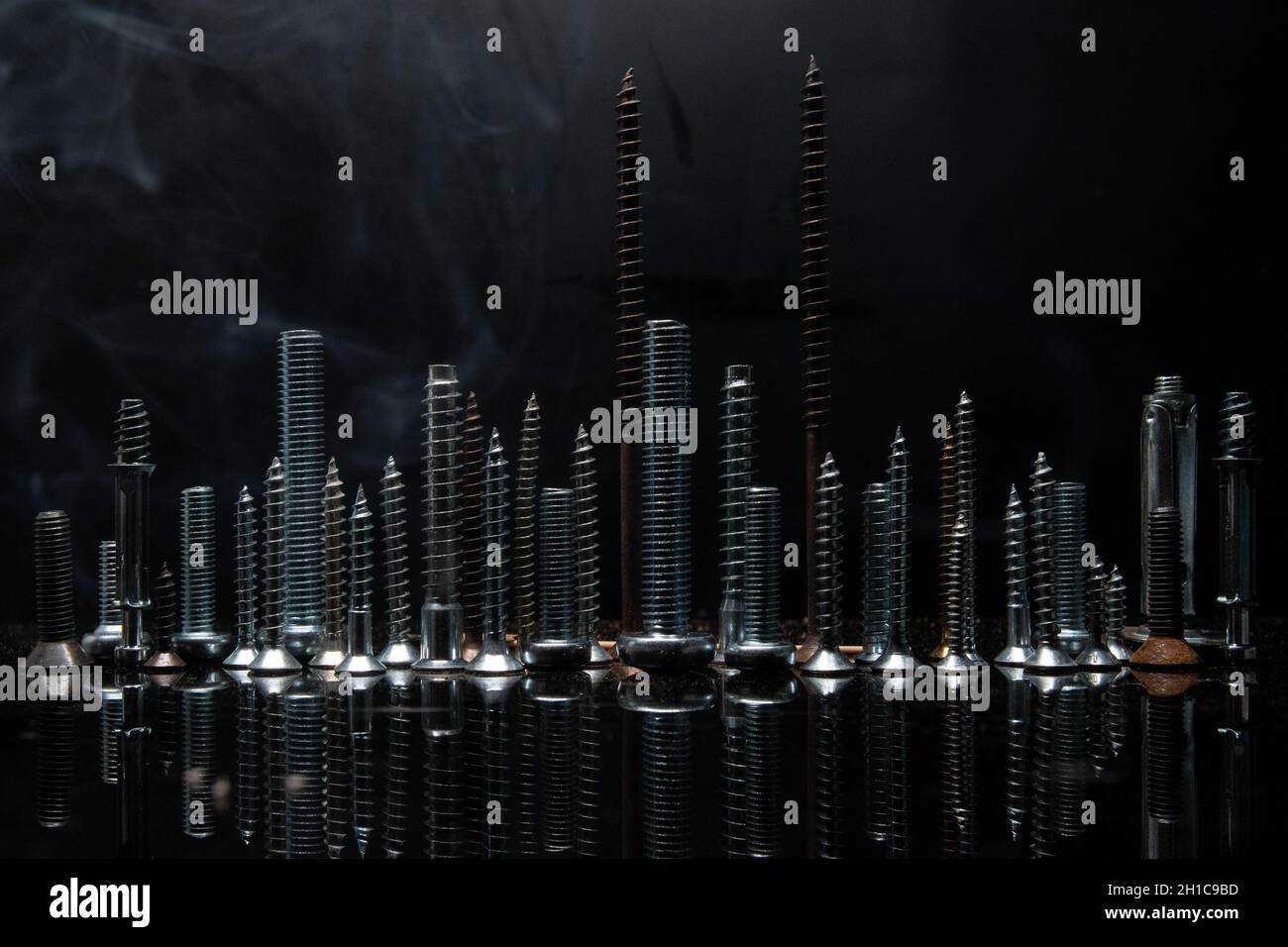 Skyline with various screws and bolts on a reflective surface in the ...