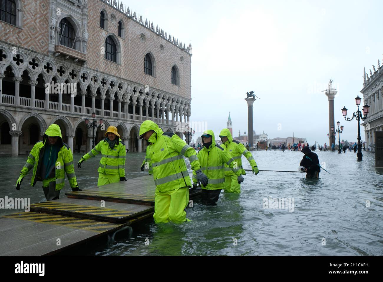 Workers are seen in the flooded St. Mark's Square during high tide, in ...