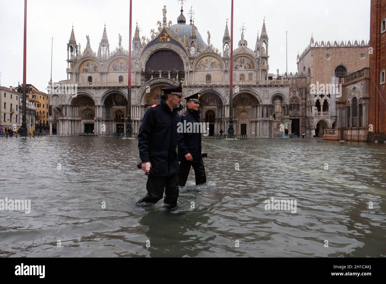 Police officer patrol a flooded St. Mark's Square during high tide, in ...