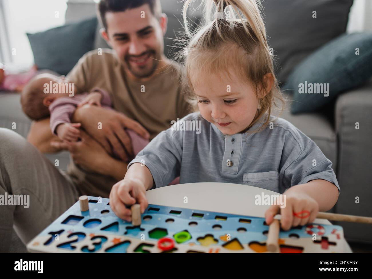 Happy young man taking care of his newborn baby and little daughter ...