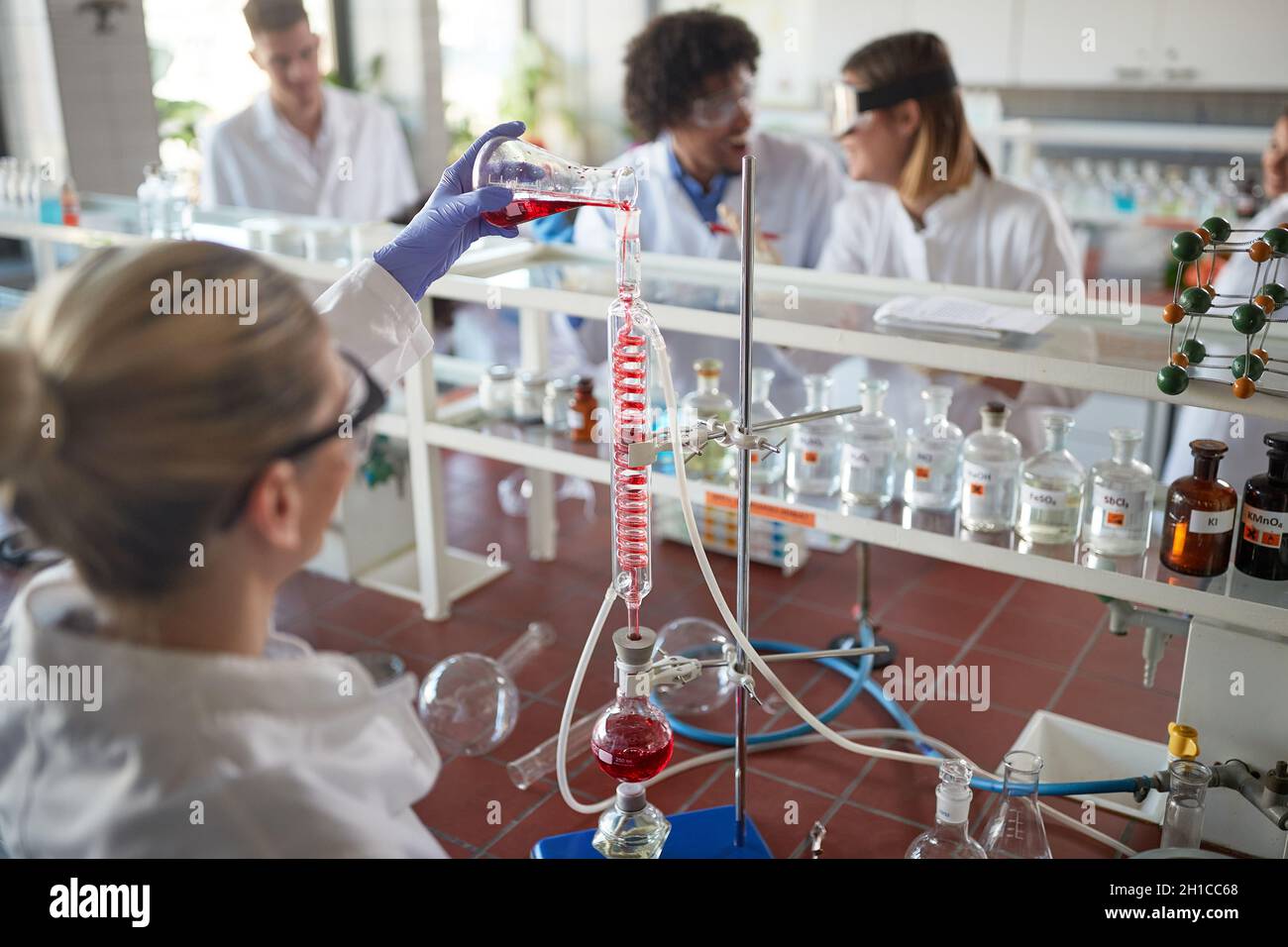 Young chemistry students having a good time while working on an ...